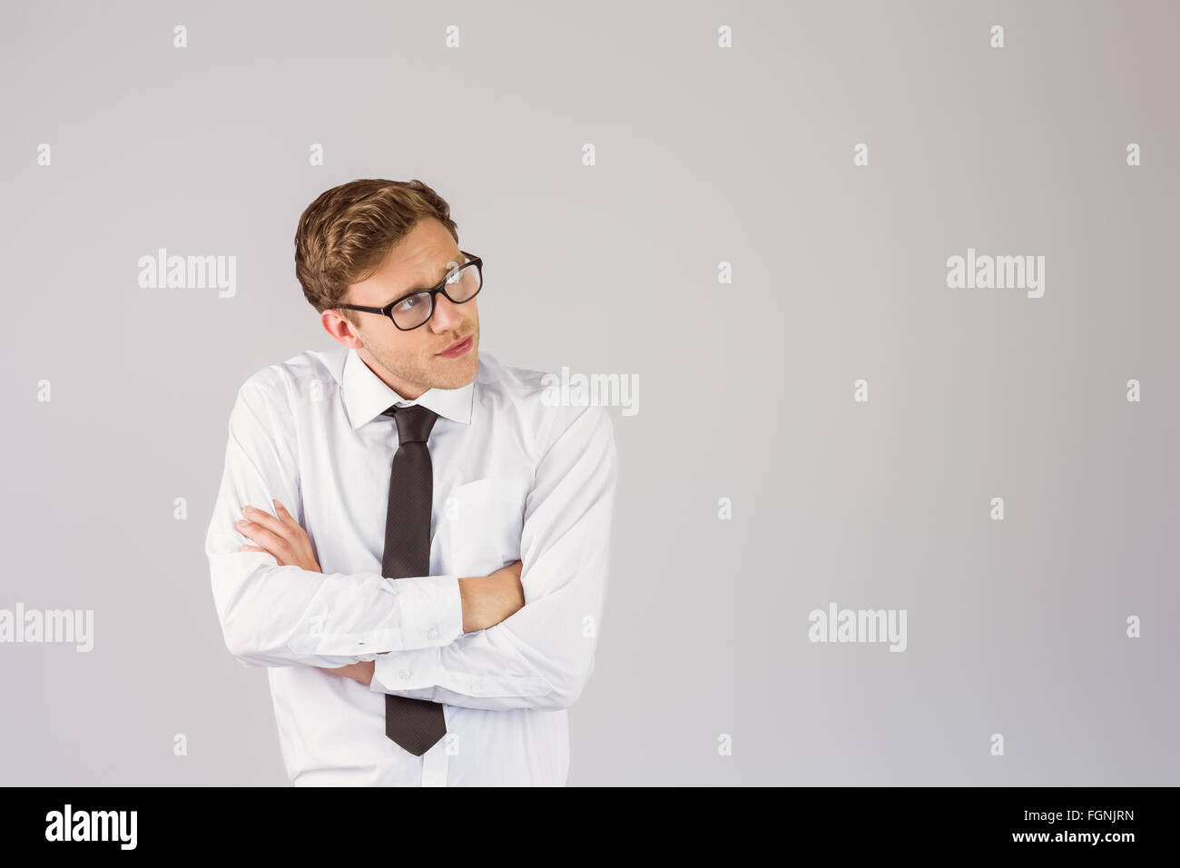 Young businessman thinking with arms crossed Stock Photo - Alamy