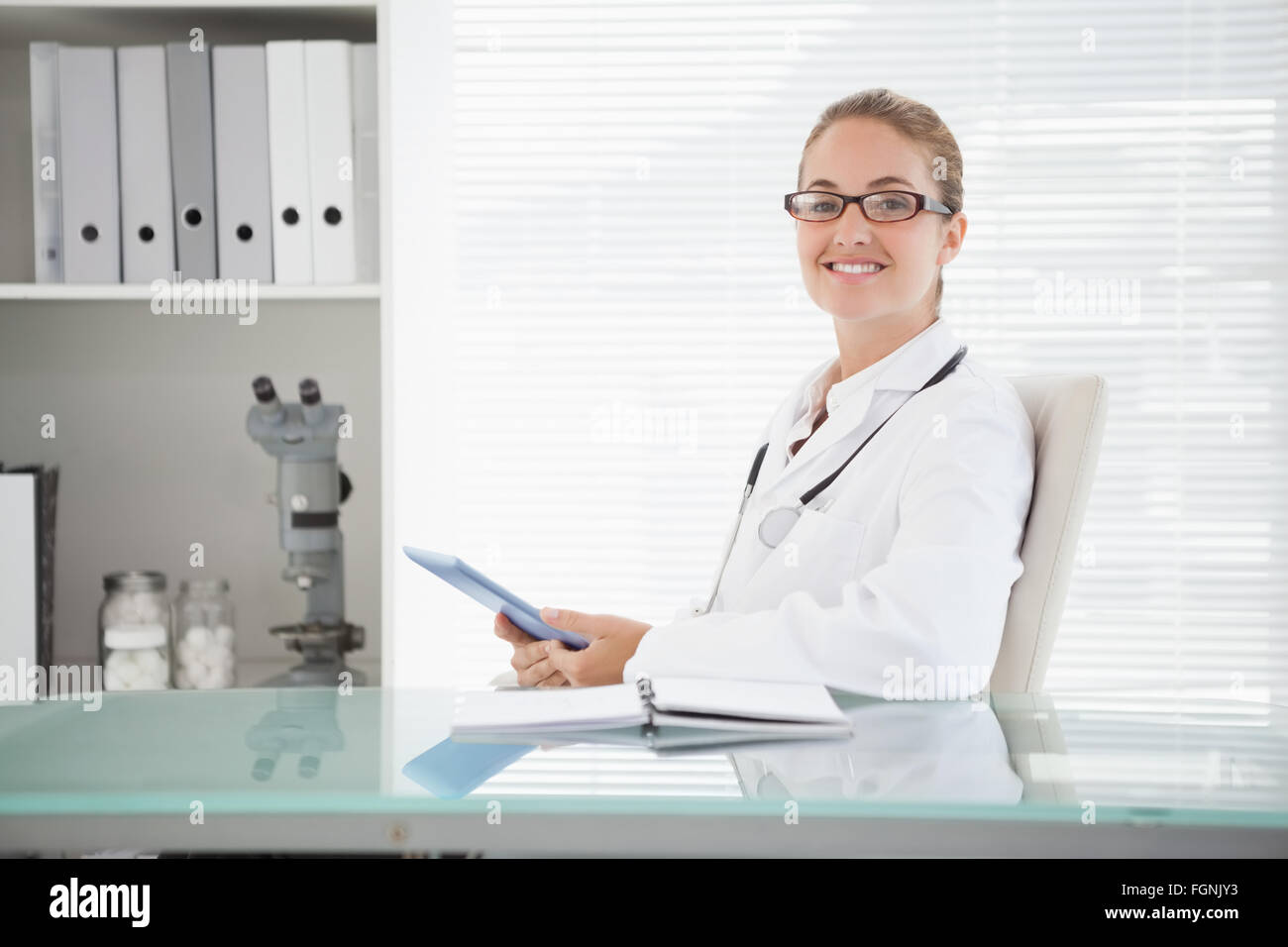 Smiling doctor using her tablet Stock Photo - Alamy