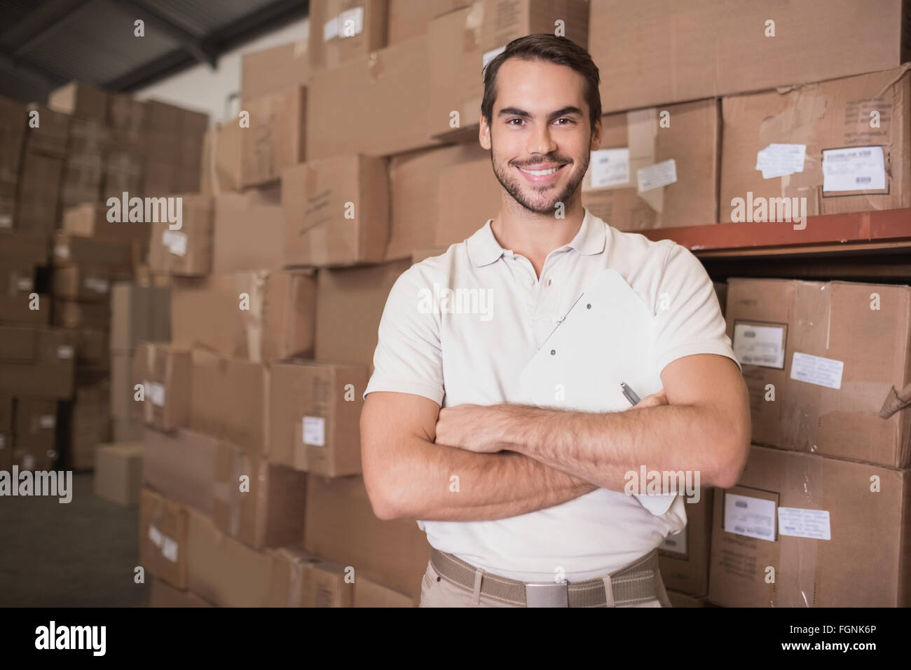 Confident worker smiling in warehouse Stock Photo - Alamy