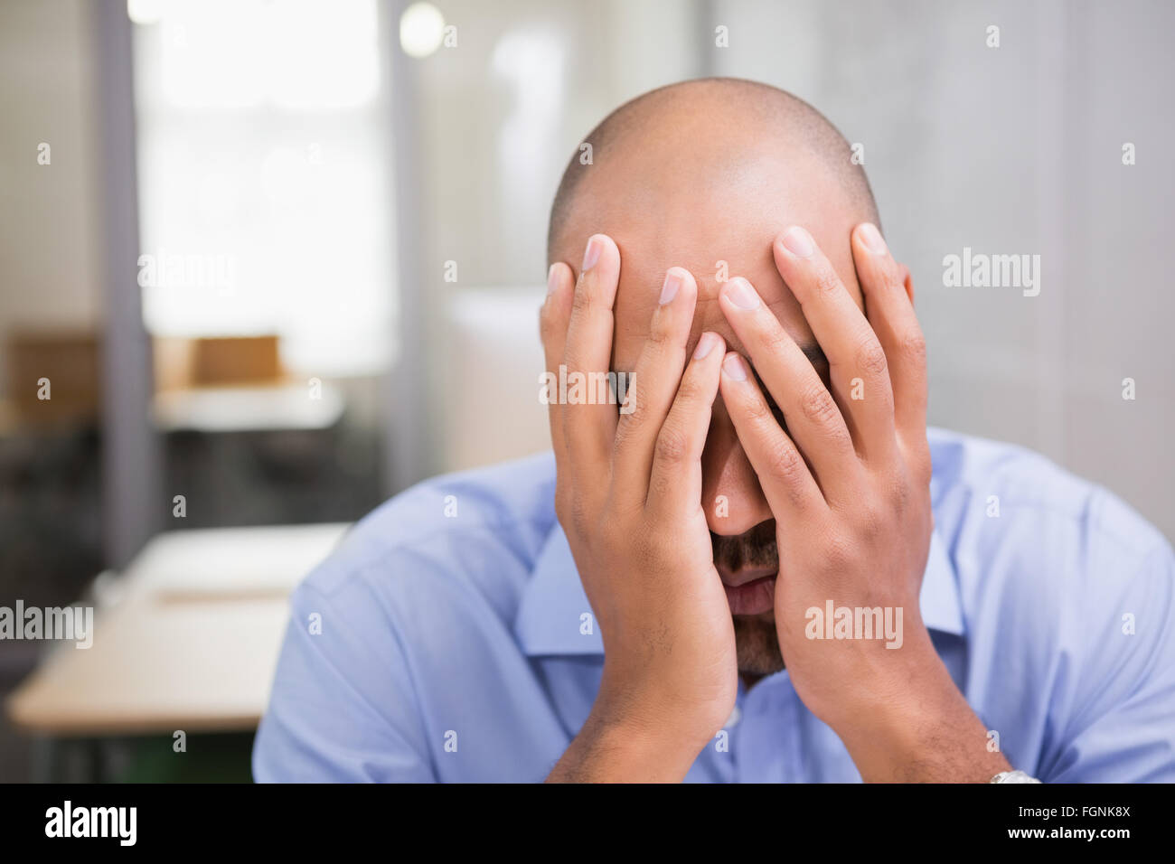 Businessman with head in hands at office Stock Photo - Alamy