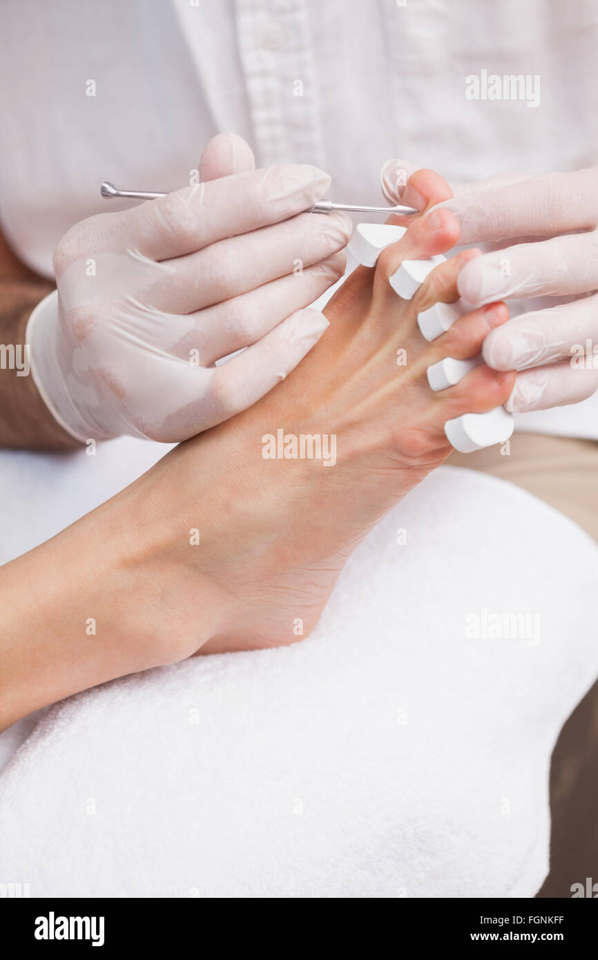 Pedicurist cleaning a customers toe nails Stock Photo - Alamy