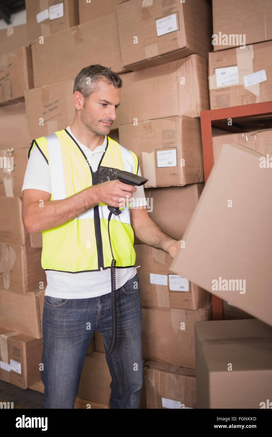 Worker scanning package in warehouse Stock Photo - Alamy