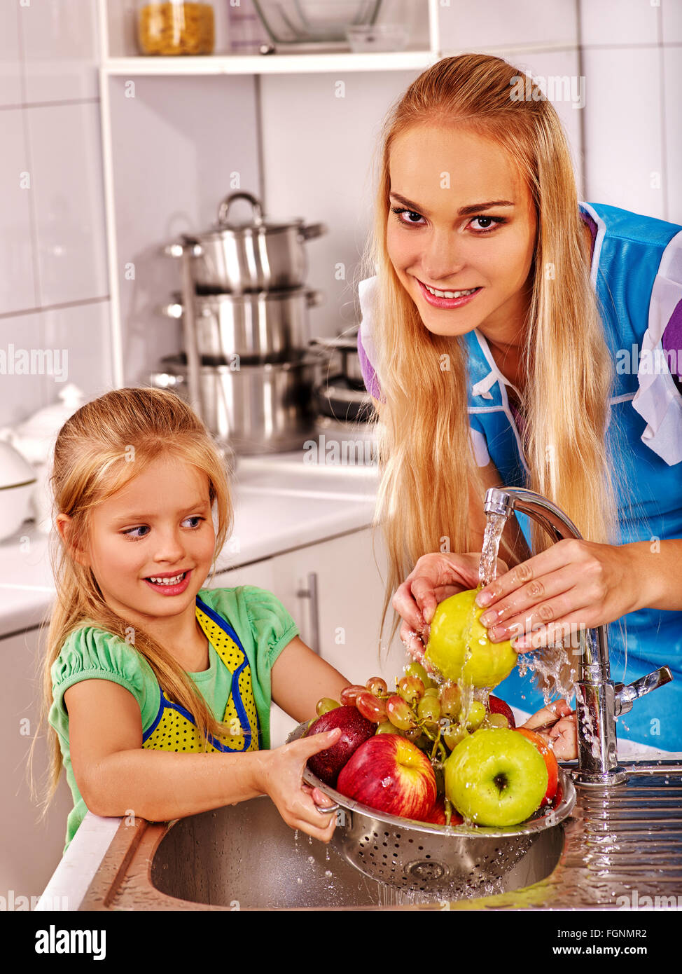 Mother and little kid is washing fruit at kitchen Stock Photo - Alamy