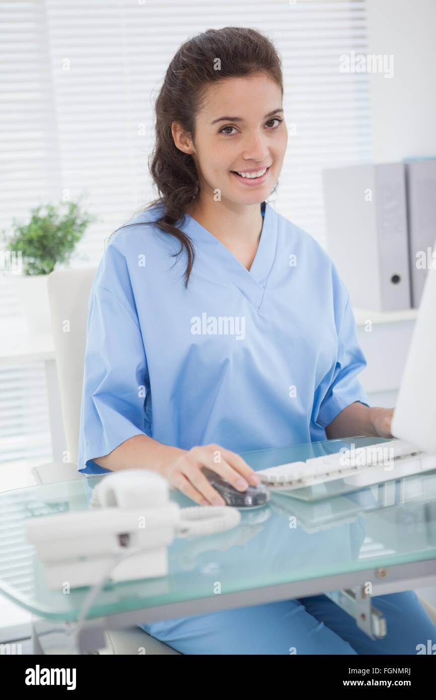 Smiling doctor using mouse of computer Stock Photo - Alamy