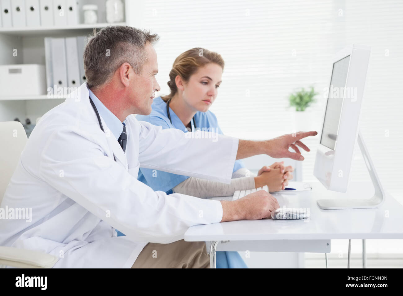 Doctor looking computer screen examination room hi-res stock ...