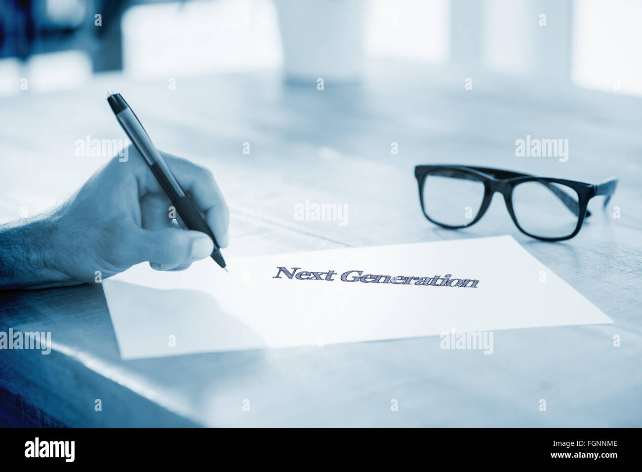 Next generation against side view of hand writing on white page on ...