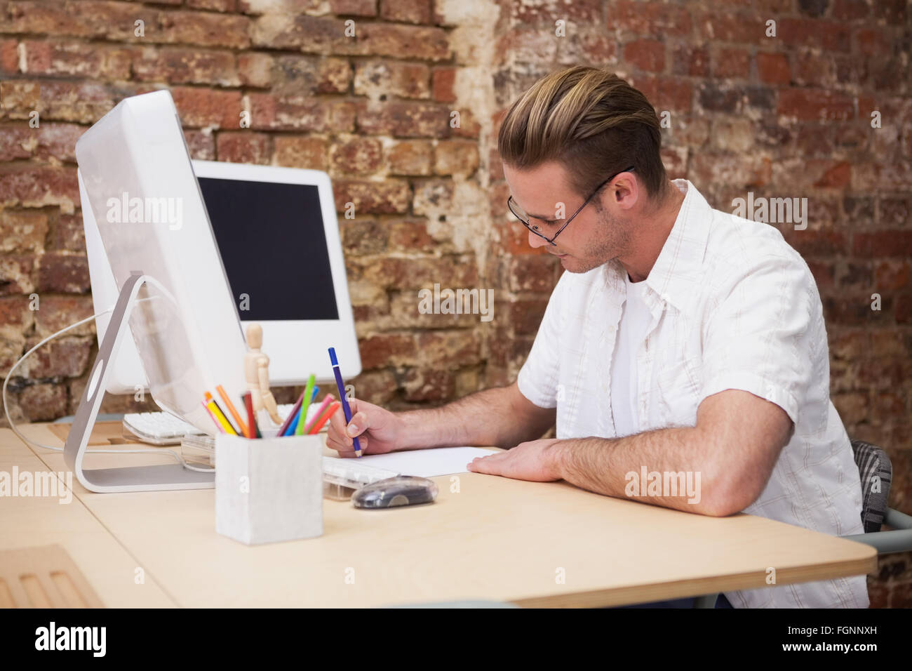 Handsome happy man using computer taking notes Stock Photo - Alamy