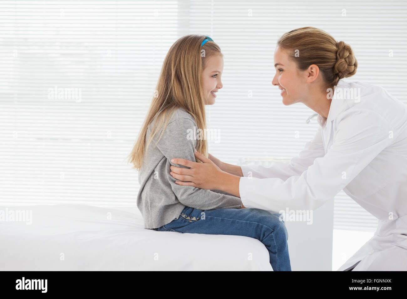 Happy doctor making patient smile Stock Photo - Alamy