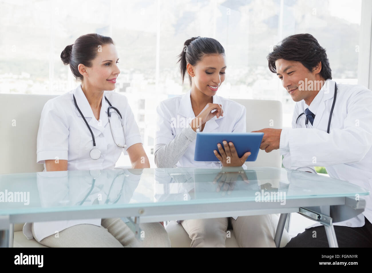 Smiling doctors using a tablet pc Stock Photo - Alamy