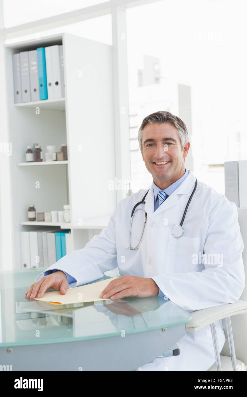 Cheerful doctor sitting at his desk Stock Photo - Alamy