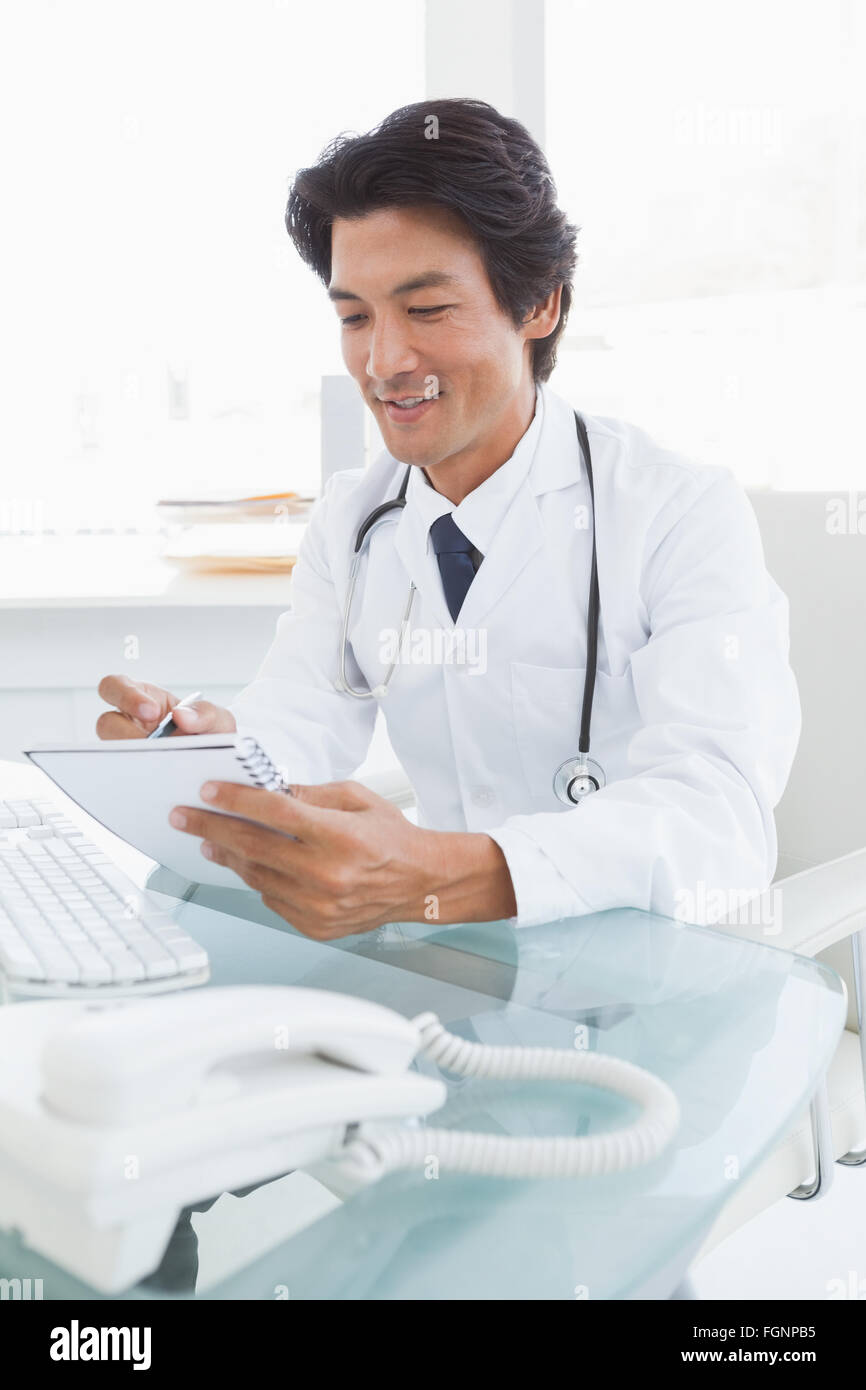 Happy doctor writing down notes Stock Photo - Alamy