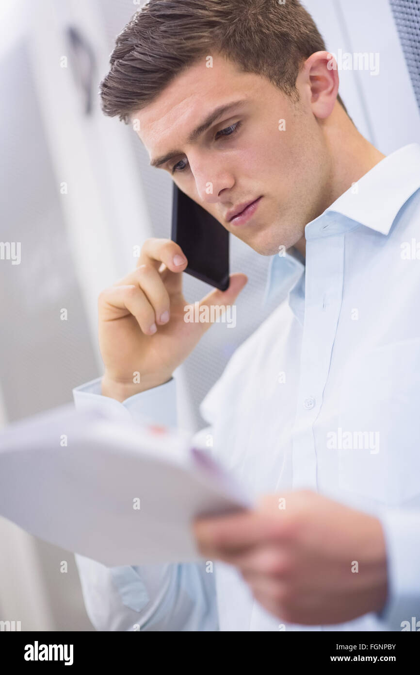 Young technician calling and reading a document Stock Photo - Alamy
