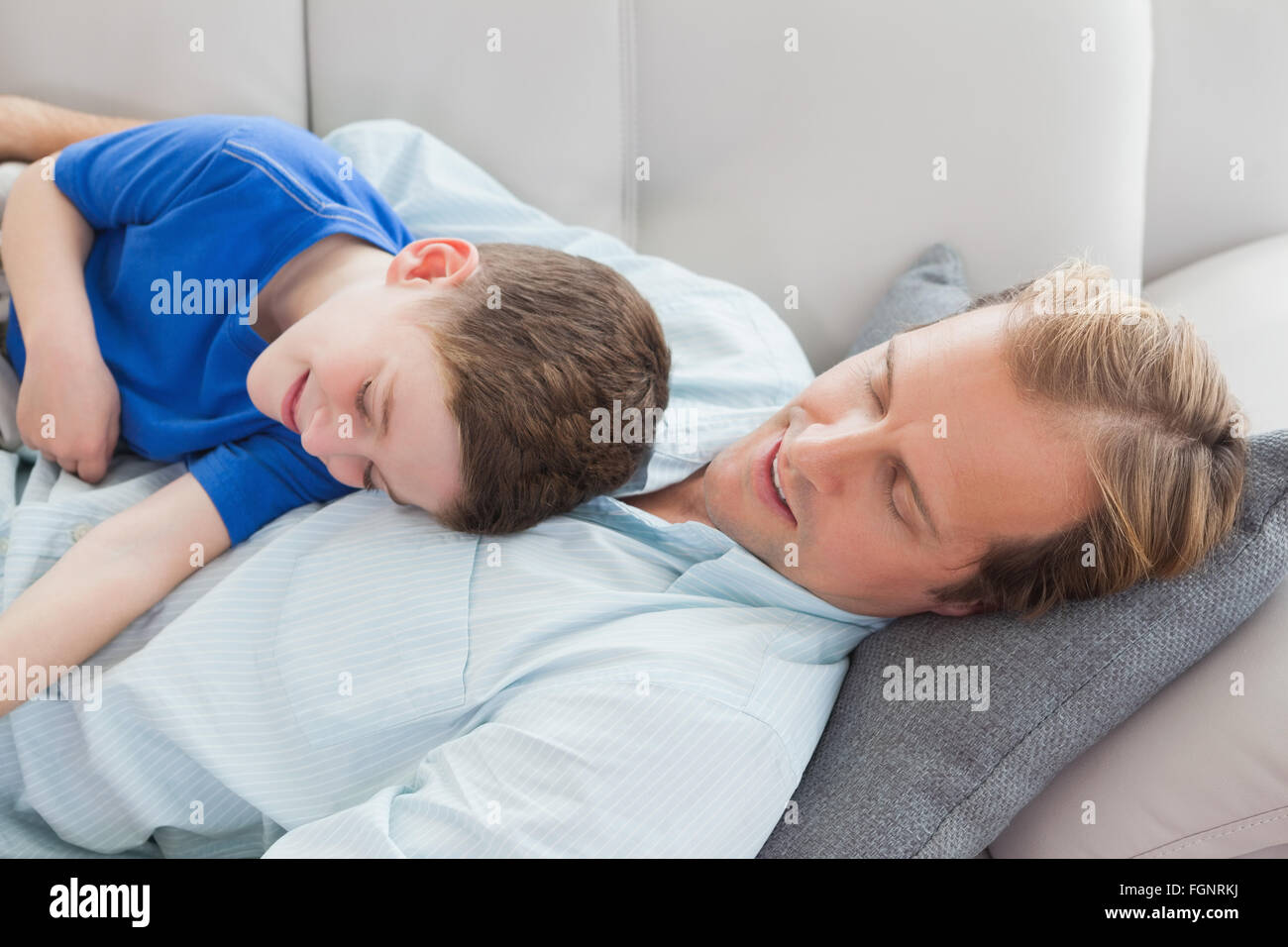 Father and son using napping on the couch Stock Photo - Alamy