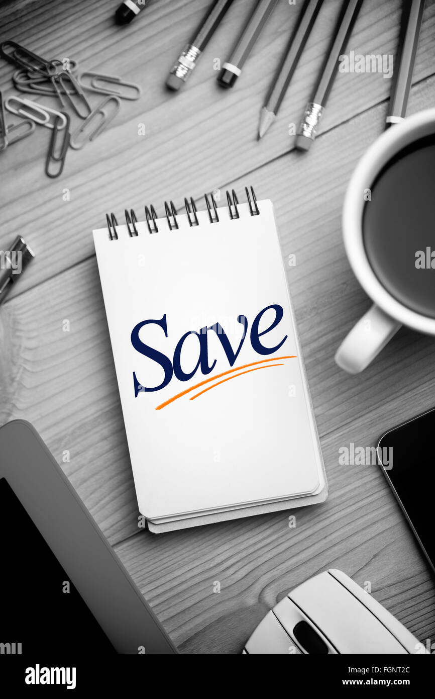 Save against notepad on desk Stock Photo - Alamy