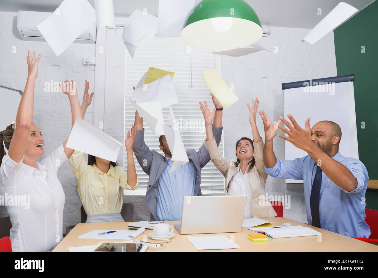 Cheerful workers throwing paper and smiling Stock Photo - Alamy