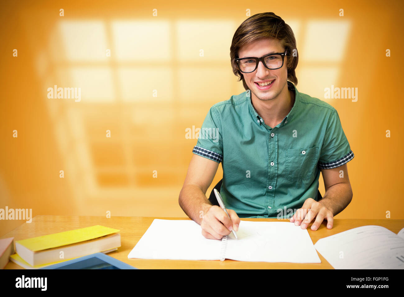 Composite image of student sitting in library writing Stock Photo - Alamy