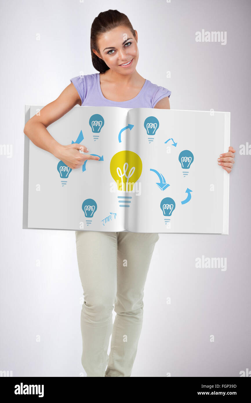 Composite image of pretty woman showing a book Stock Photo - Alamy