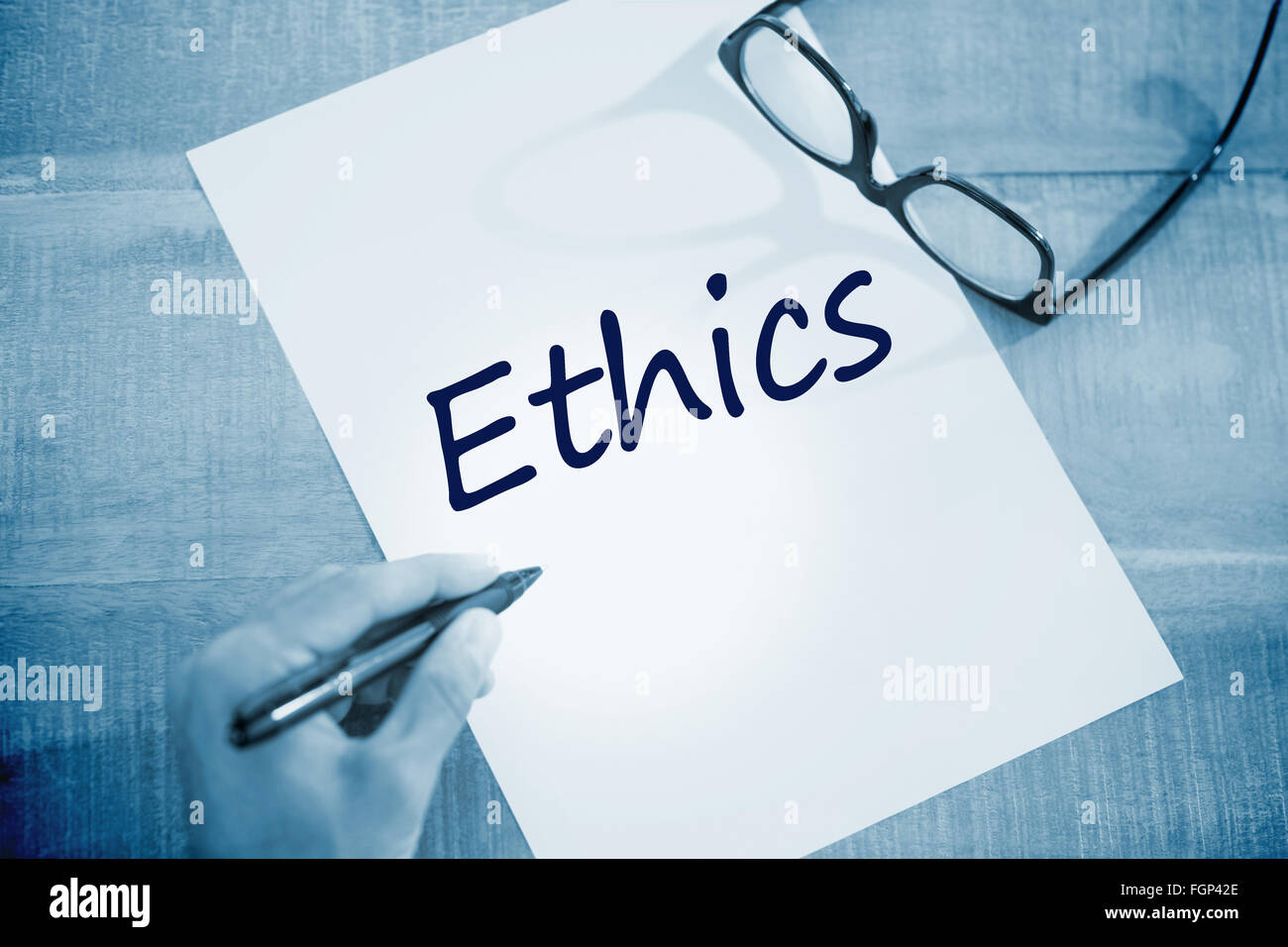 Ethics against left hand writing on white page on working desk Stock ...