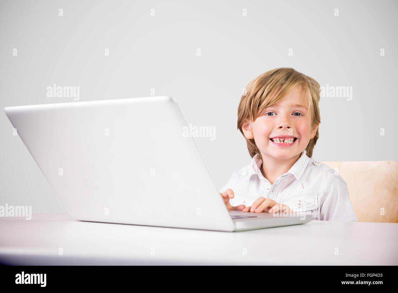 Composite image of cute boy using laptop Stock Photo - Alamy
