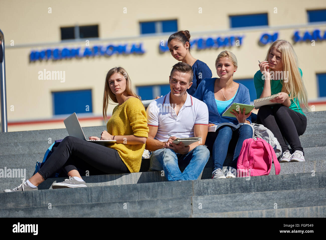 students outside sitting on steps Stock Photo - Alamy