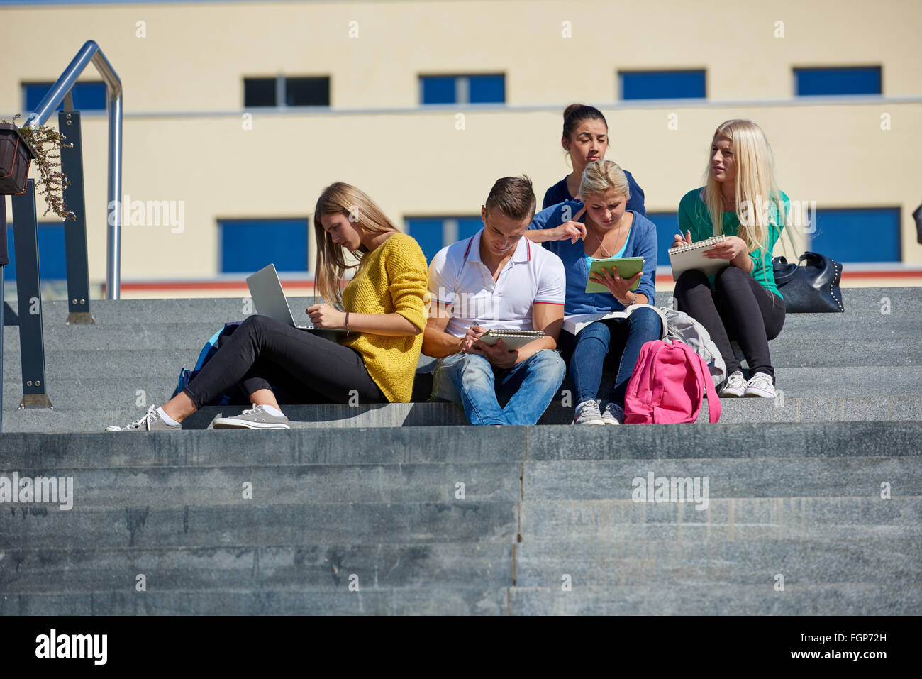 students outside sitting on steps Stock Photo - Alamy