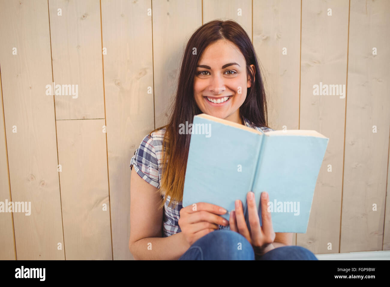 Pretty hipster reading blue book Stock Photo - Alamy