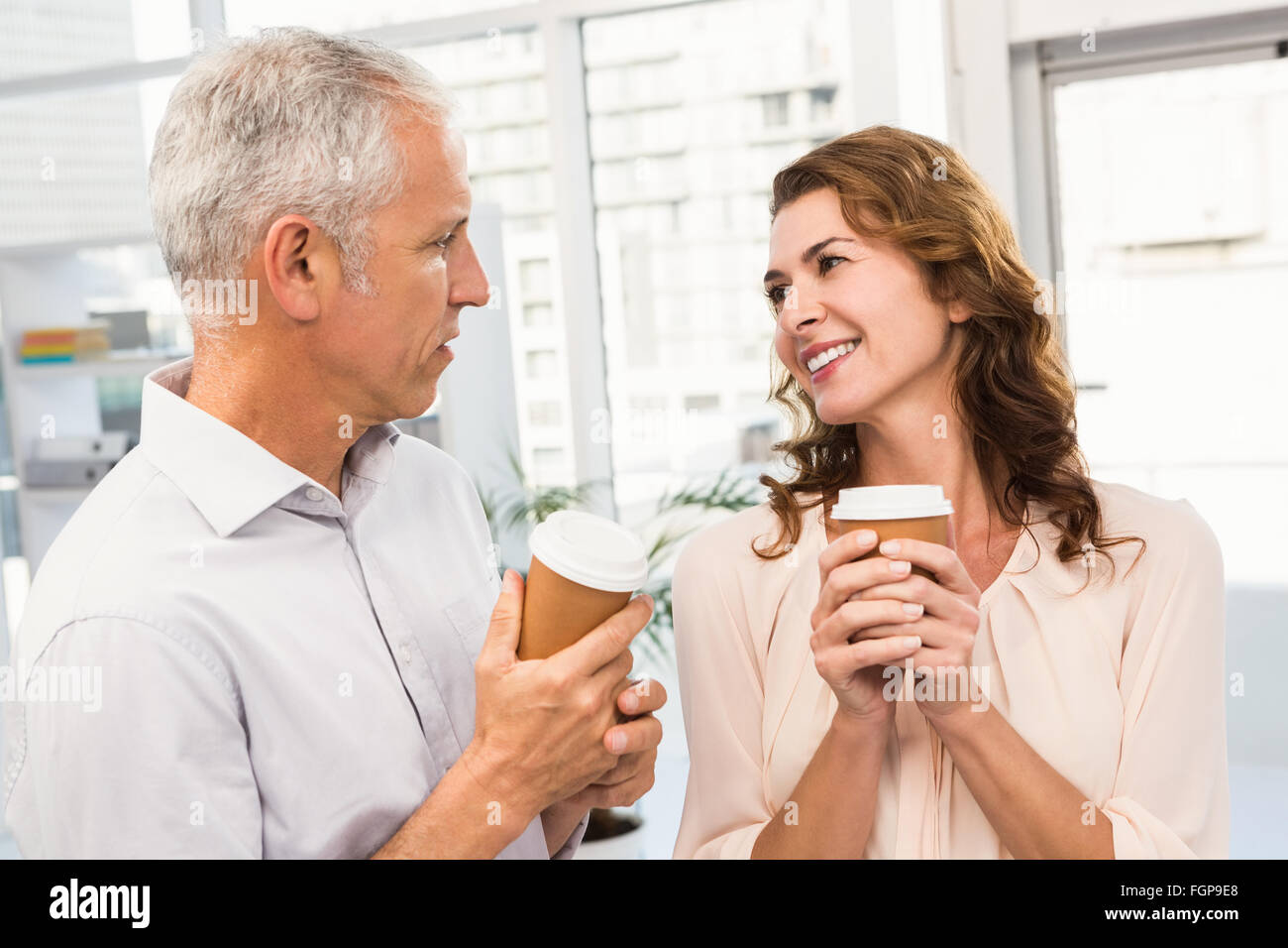 Smiling casual business colleagues having coffee together Stock Photo ...