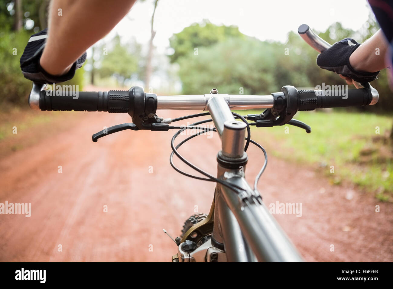 Woman mountain biking and holding handlebars Stock Photo - Alamy