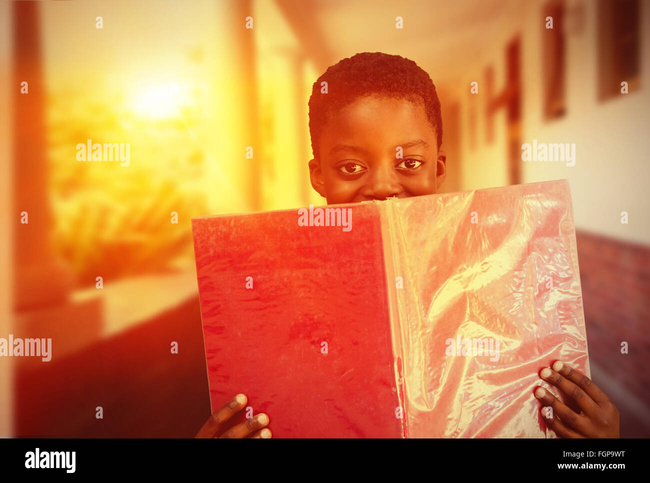 Composite image of cute boy reading book in library Stock Photo - Alamy