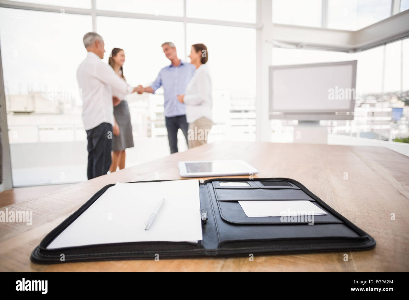 Planner in front of handshaking business people Stock Photo - Alamy