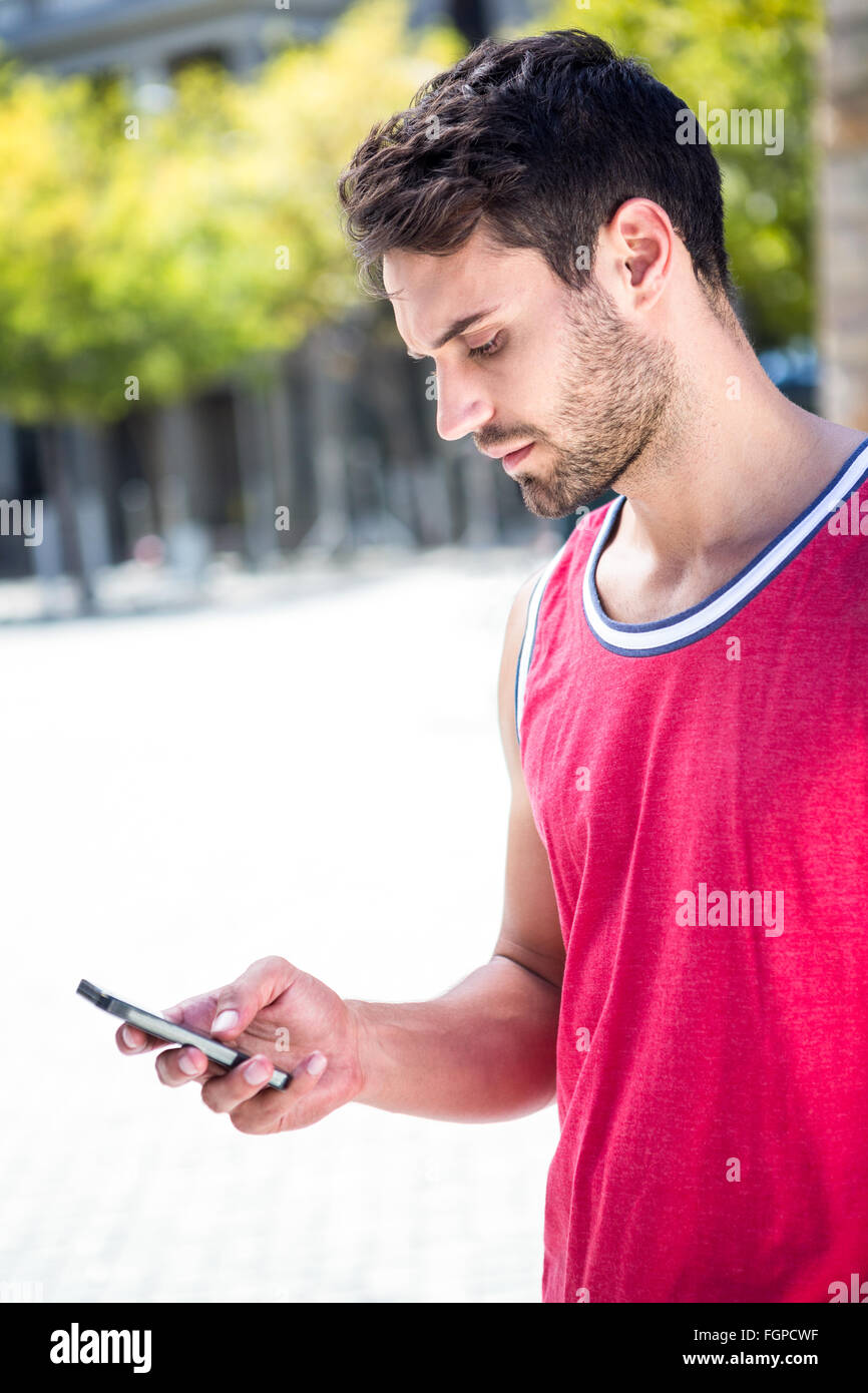 Handsome athlete sending a text Stock Photo - Alamy