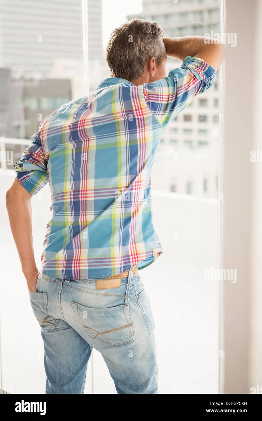 Rear view of troubled casual businessman leaning against window Stock ...