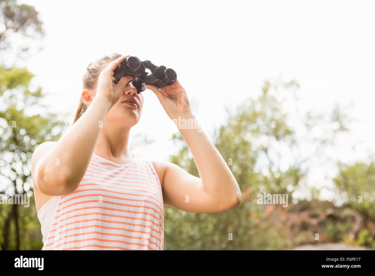 Pretty blonde looking through binoculars Stock Photo - Alamy