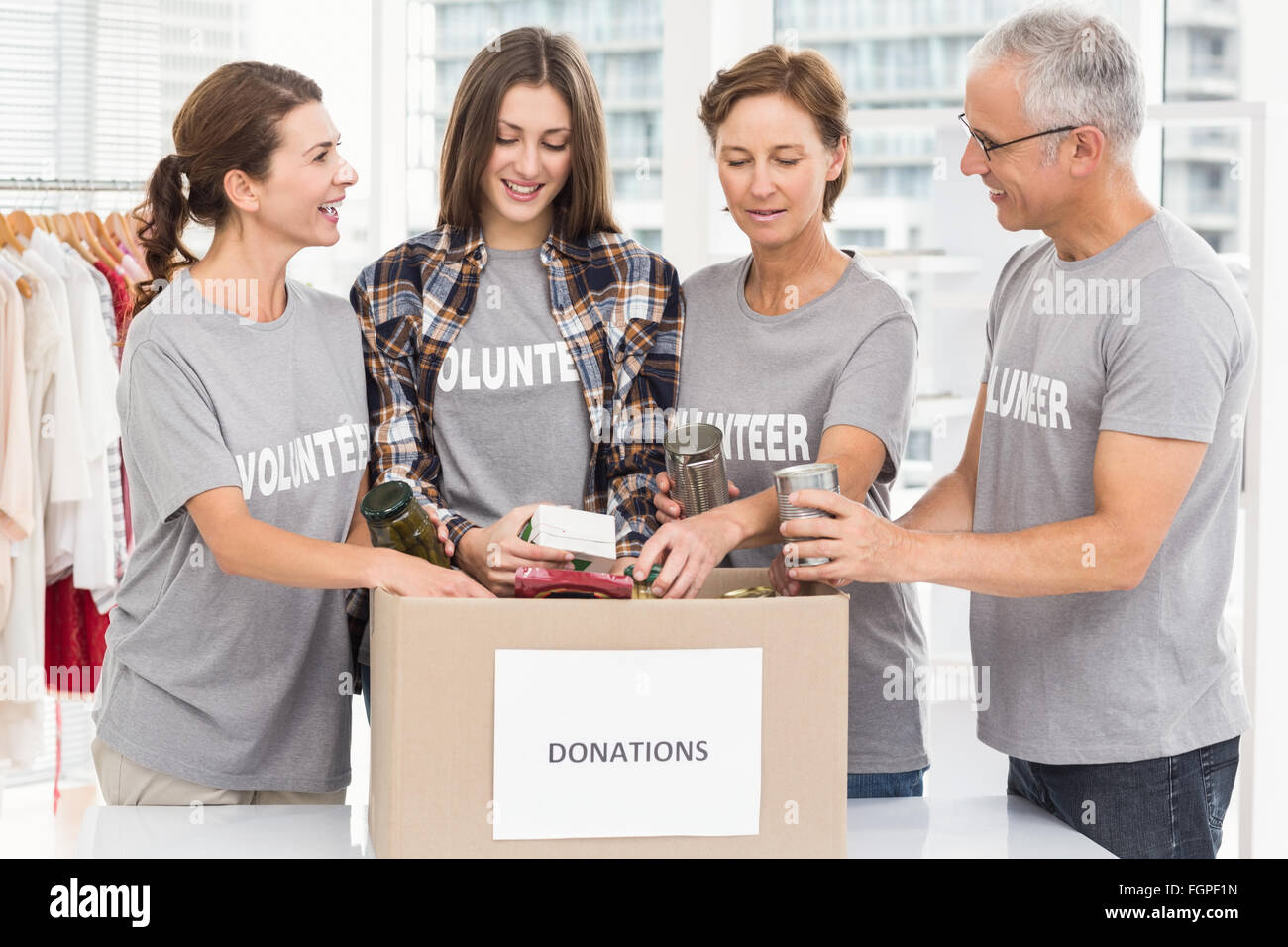 Smiling volunteers sorting donation box Stock Photo - Alamy