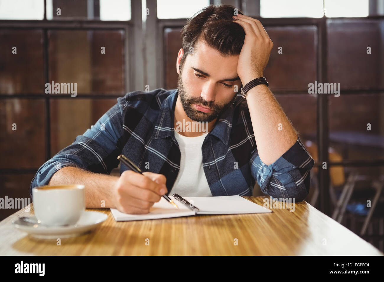 Young man taking notes in his notebook Stock Photo - Alamy