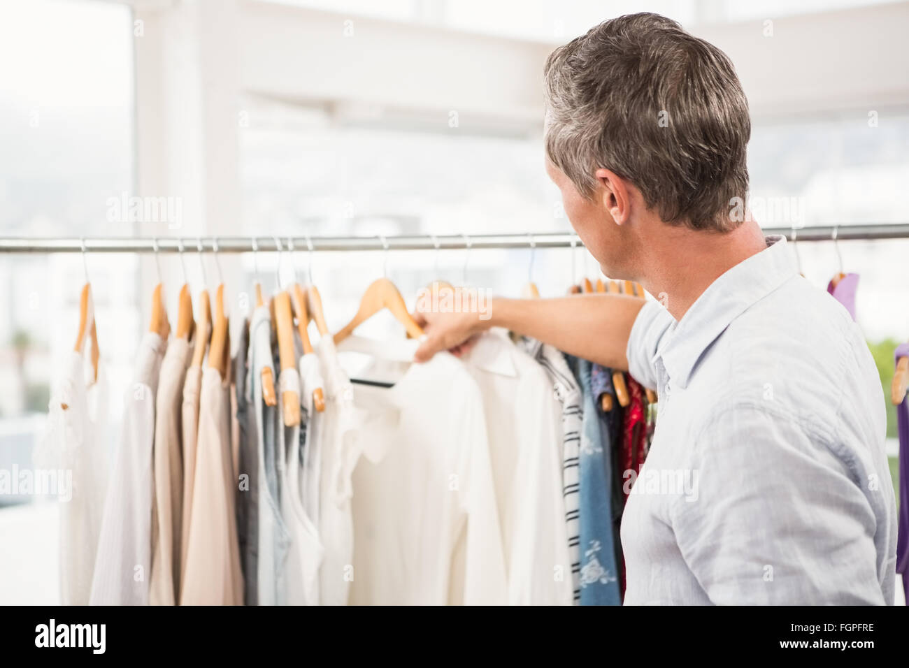 Rear view of man browsing clothes Stock Photo - Alamy