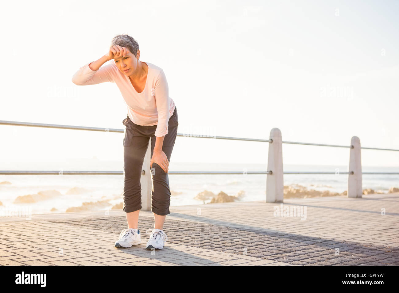 Sweating sporty woman resting at promenade Stock Photo - Alamy