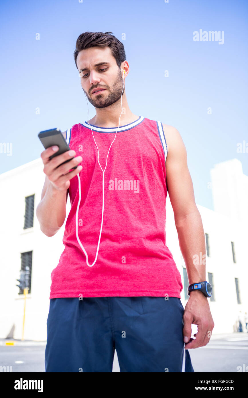 Handsome athlete sending a text Stock Photo - Alamy