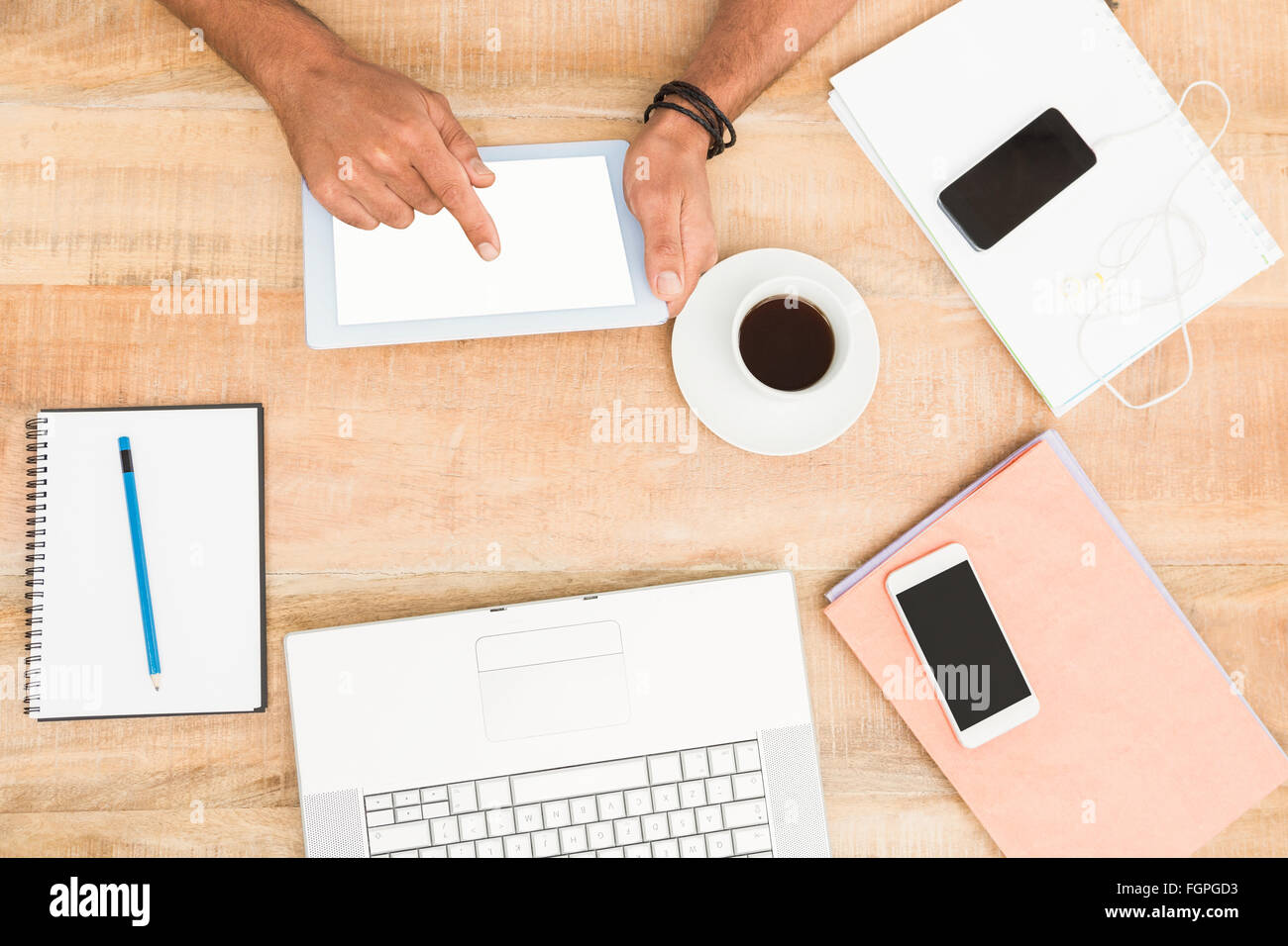Hands using tablet next to several devices Stock Photo - Alamy