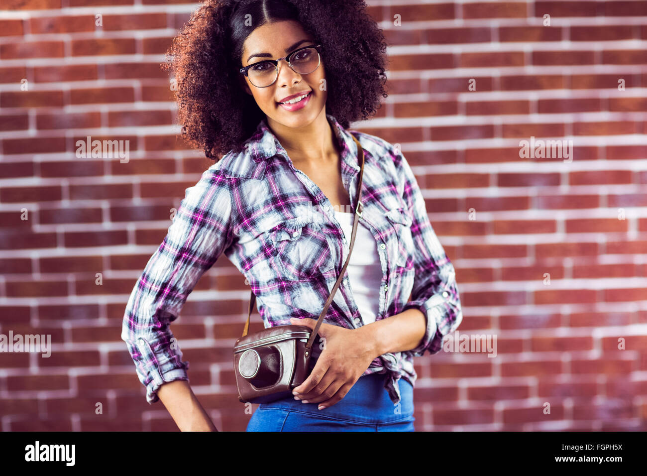 Attractive smiling hipster posing with camera Stock Photo - Alamy