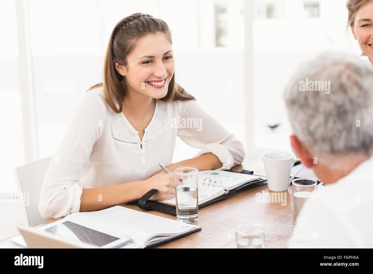 Smiling business people having a meeting Stock Photo - Alamy