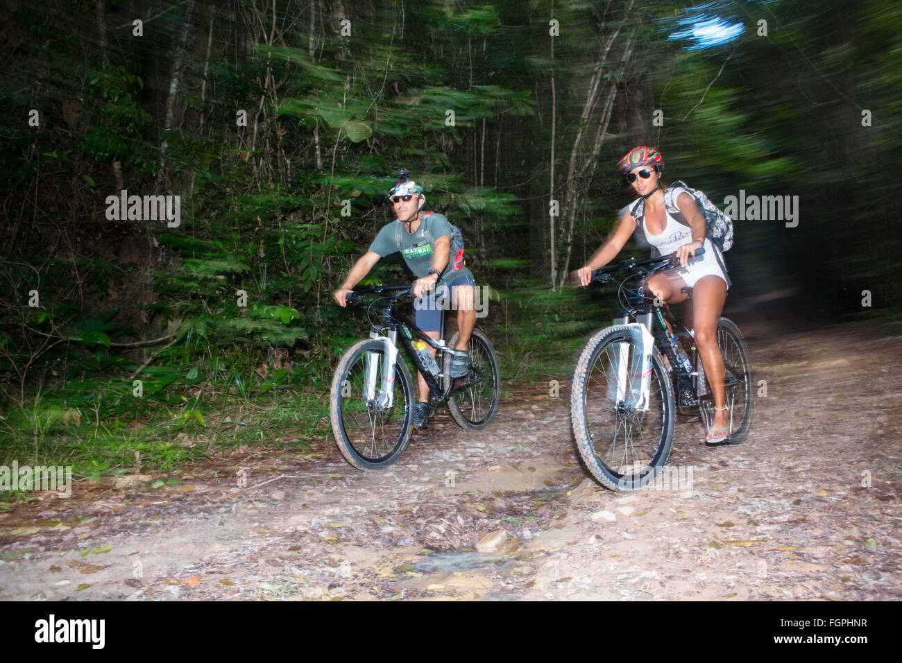 A couple riding mountain bikes through forested areas near Trancoso ...