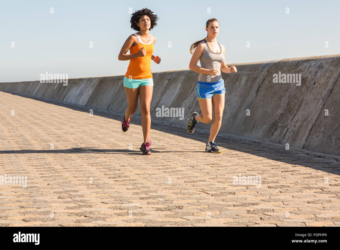 Two young women jogging together Stock Photo - Alamy