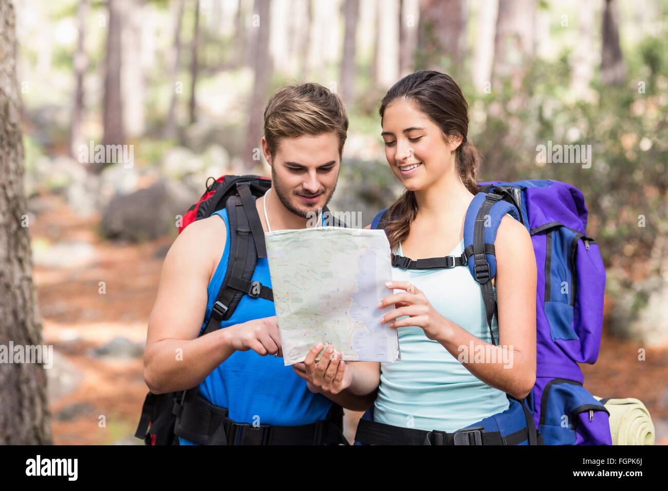 Happy hikers looking at map Stock Photo - Alamy