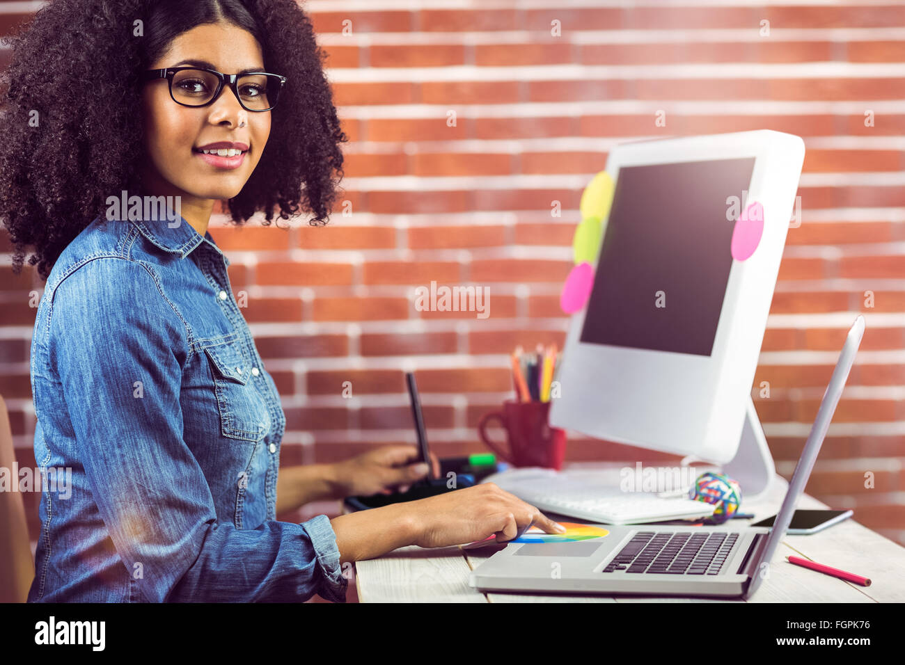 Casual female designer smiling and working Stock Photo - Alamy