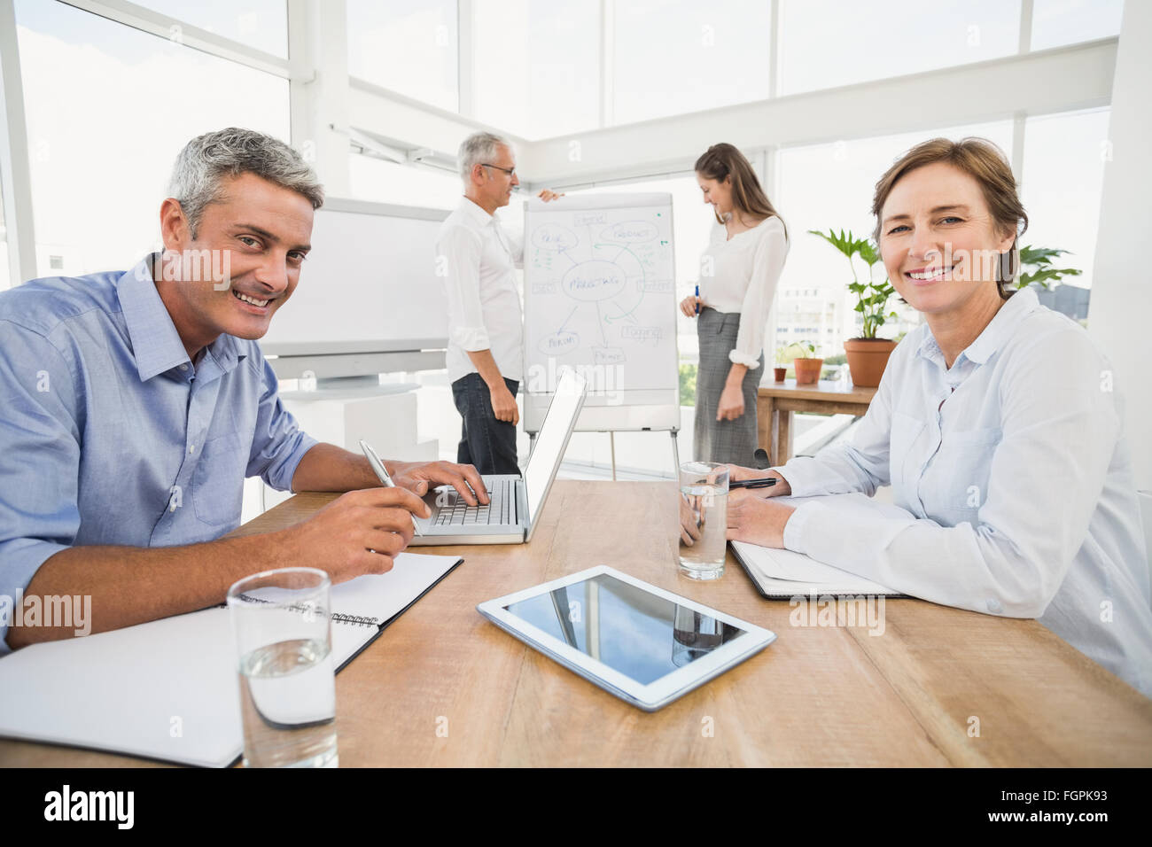 Smiling business people having a meeting Stock Photo - Alamy