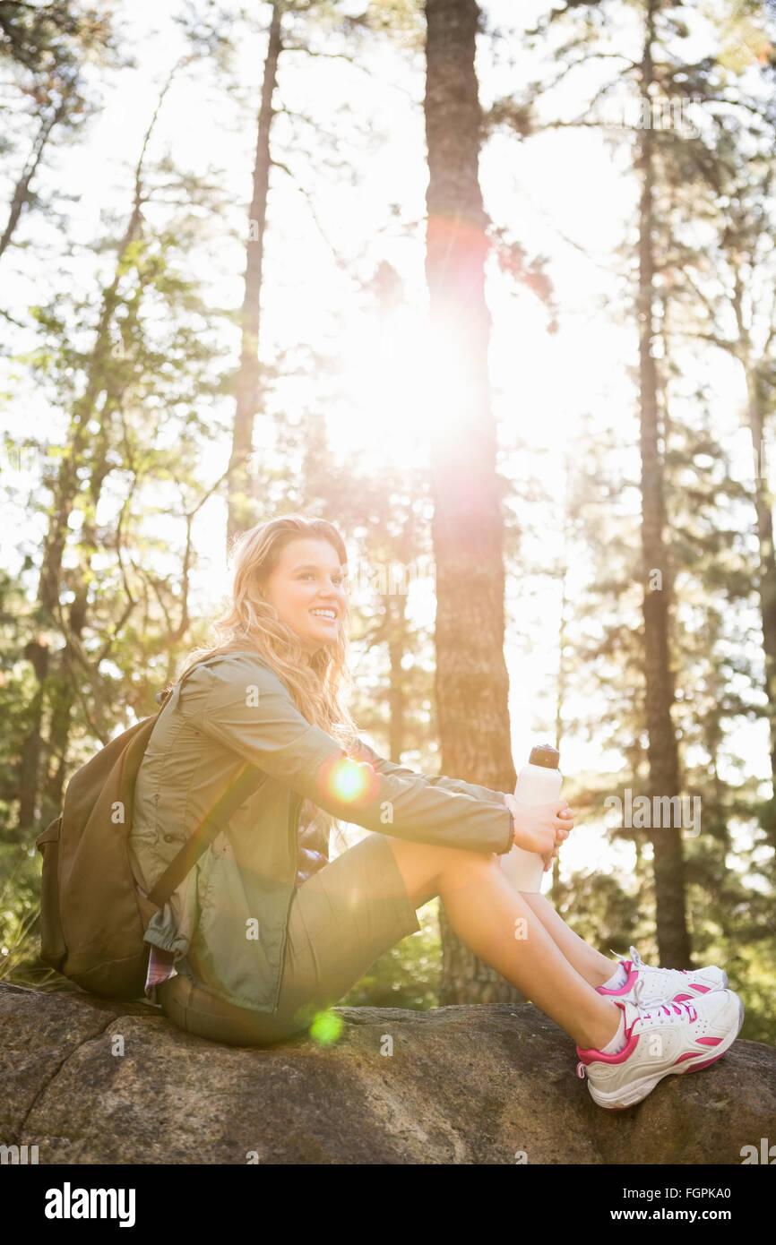 Pretty blonde hiker sitting on stone Stock Photo - Alamy