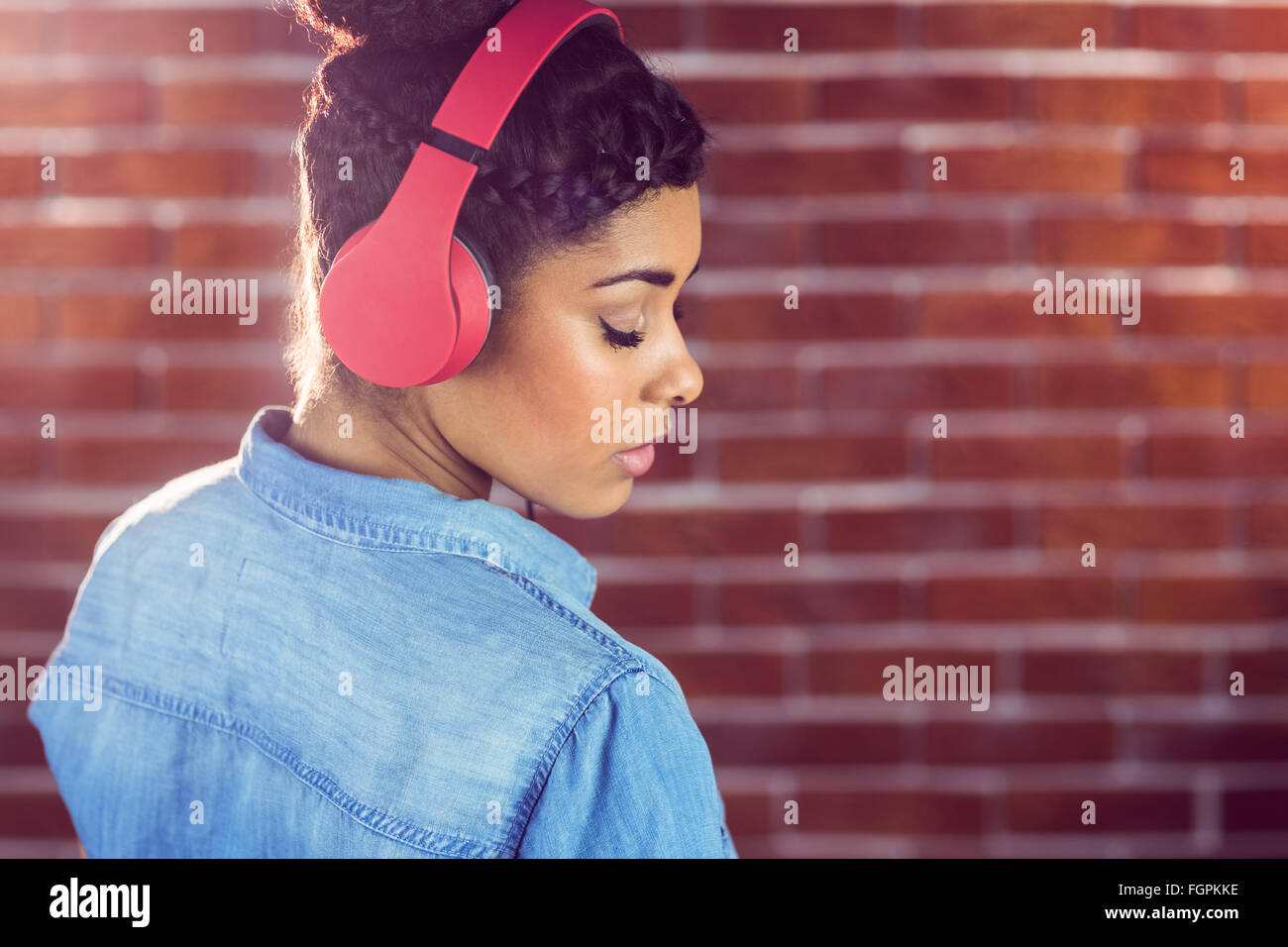 Pretty young woman with headphones looking back Stock Photo - Alamy