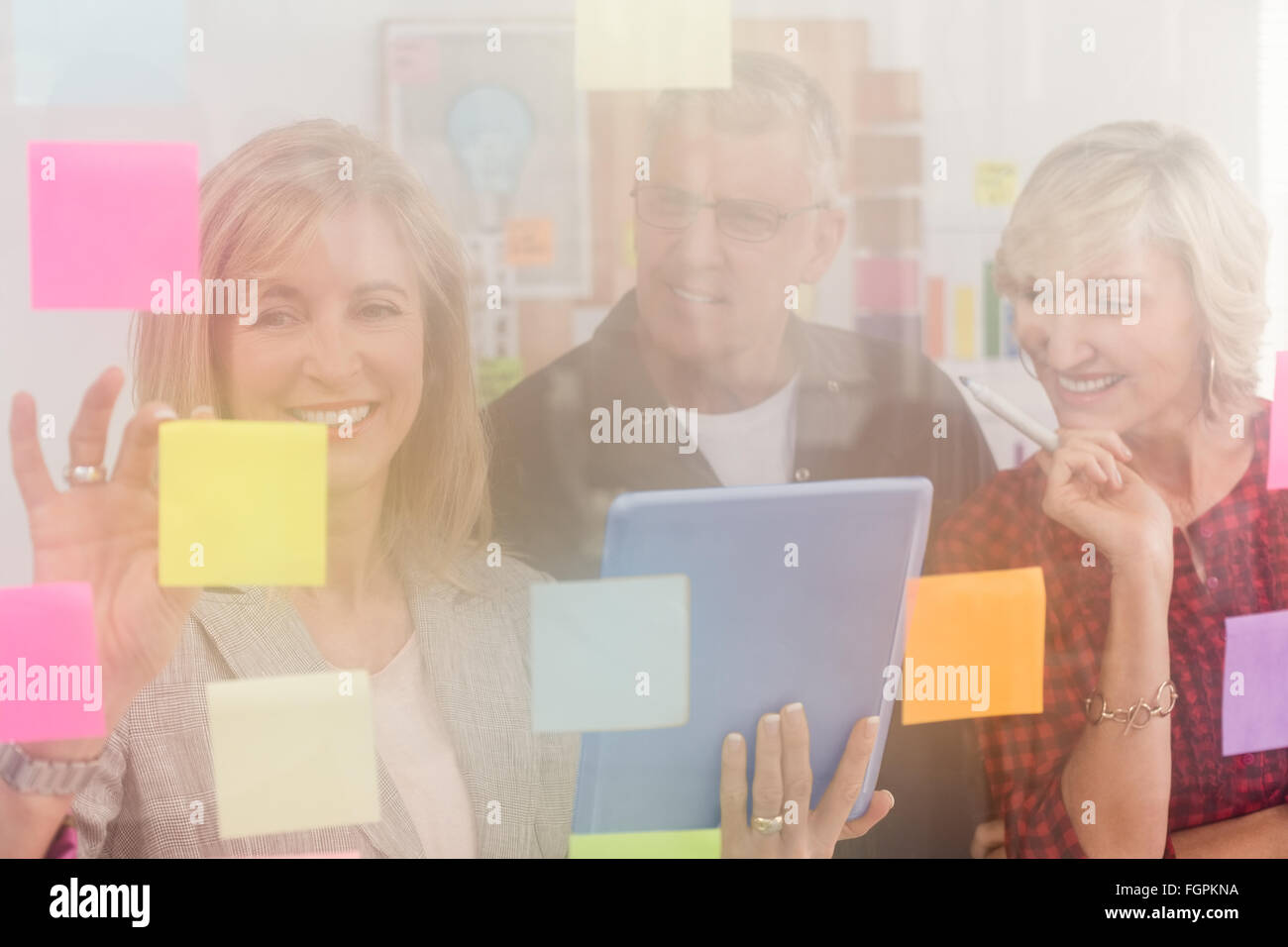 Smiling business team working on tablet Stock Photo - Alamy
