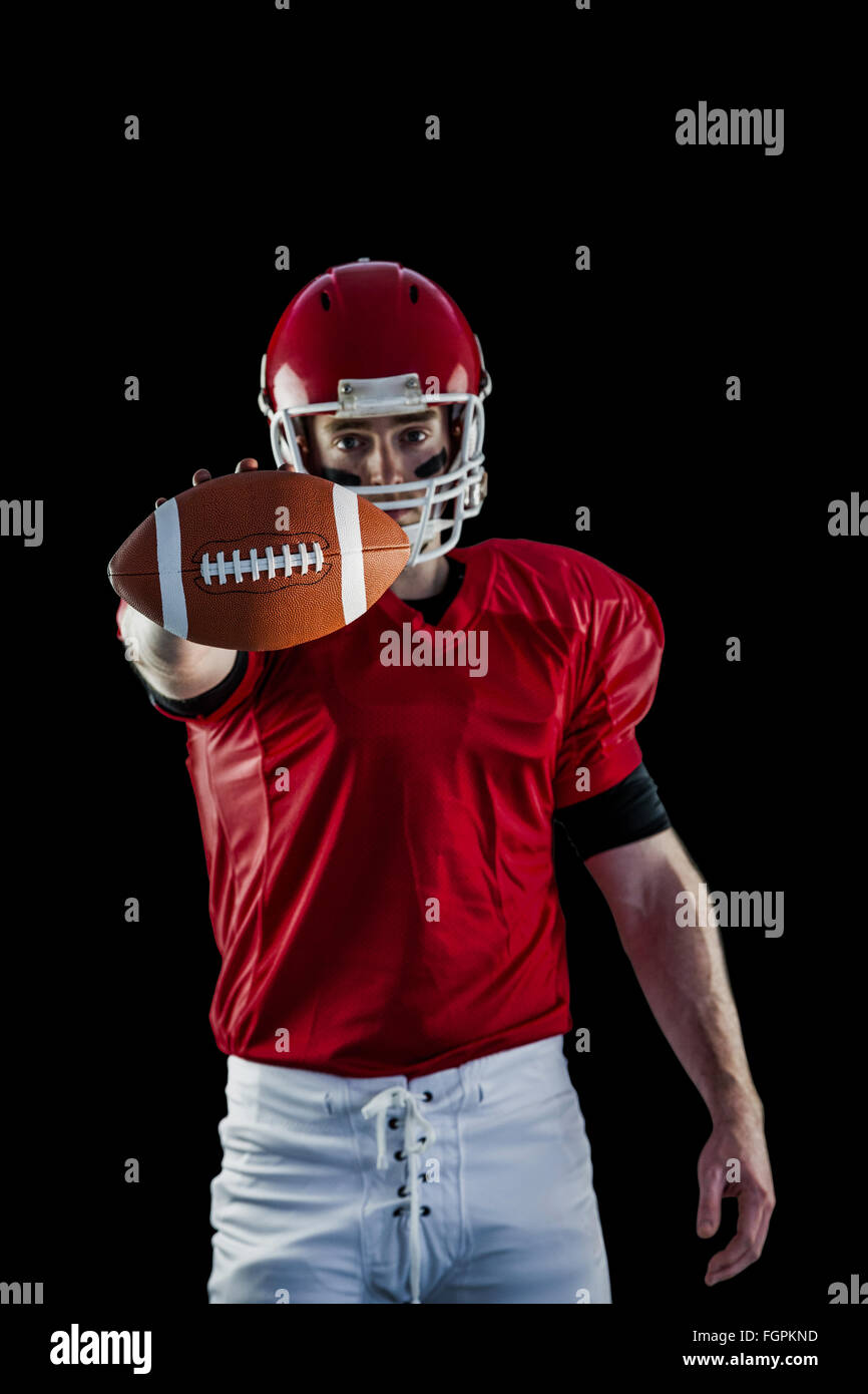 Portrait of american football player showing football to camera Stock ...